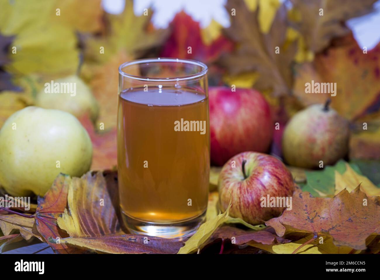 Fresh apple juice on table with apples and maple leaves Stock Photo - Alamy