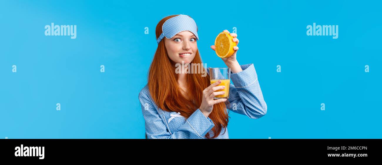 Excited and cute pretty caucasian redhead woman in pyjama and sleep ...