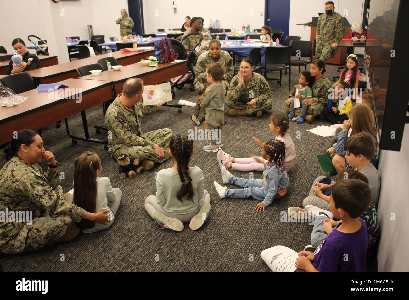 LCDR Woods reads a story to the kids Stock Photo - Alamy