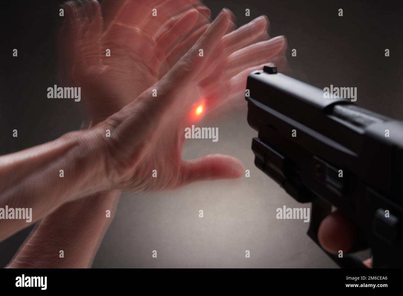 Expressive hands in front of a pistol with a laser gunsight Stock Photo ...