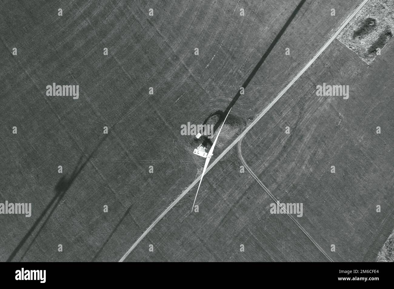 A grayscale aerial top view of a wind turbine in a field Stock Photo ...