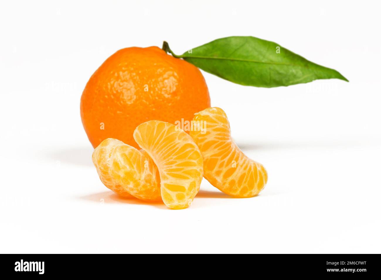 Three slices of a mandarin close-up against a whole mandarin background ...