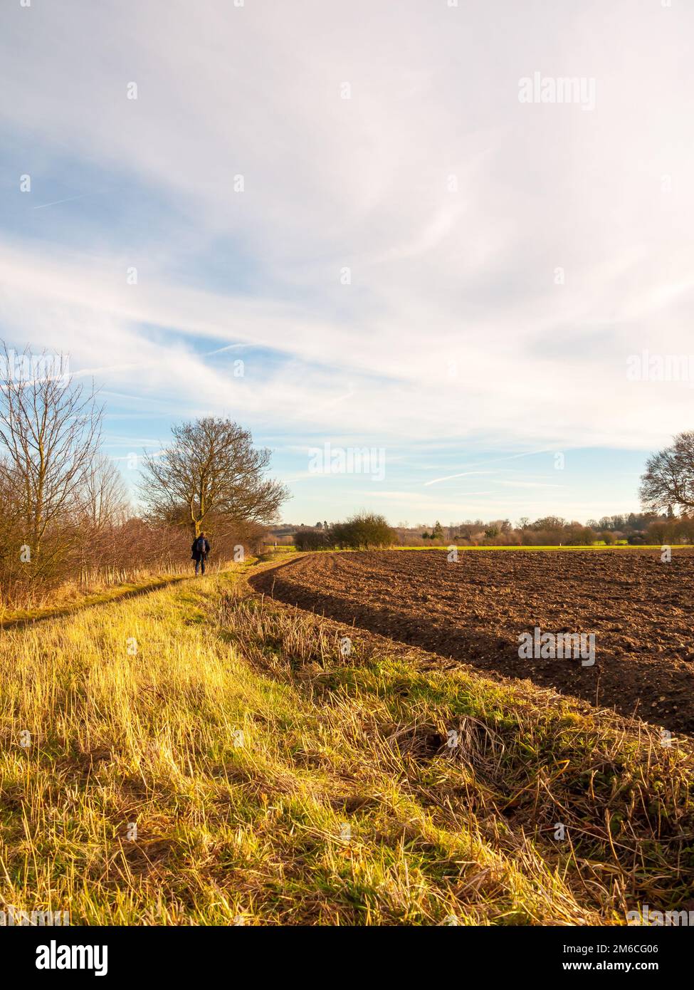 Walking through brown ploughed agricultural field outside farm ...