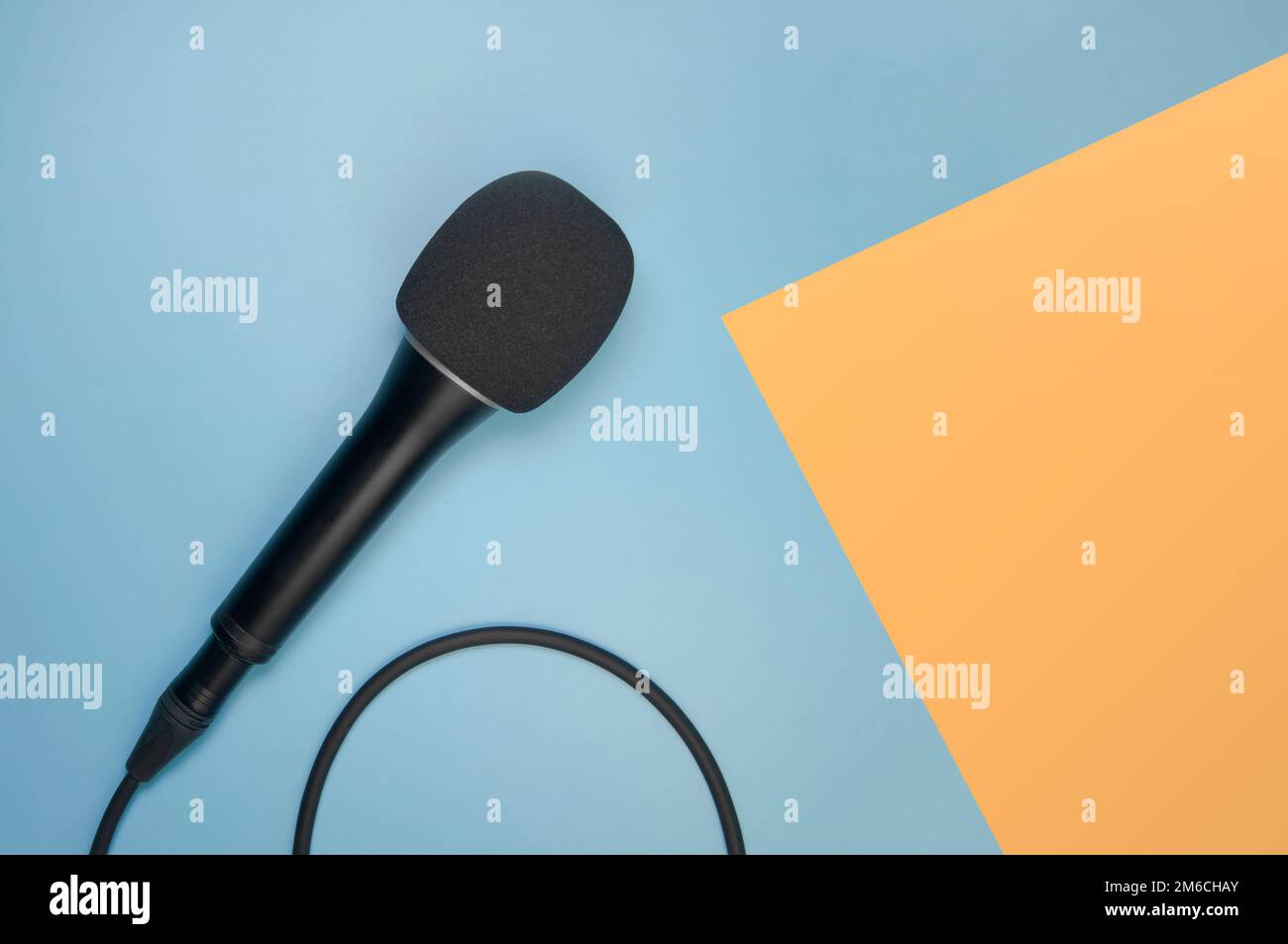 Concert microphone connected by cable on a blue background with an ...