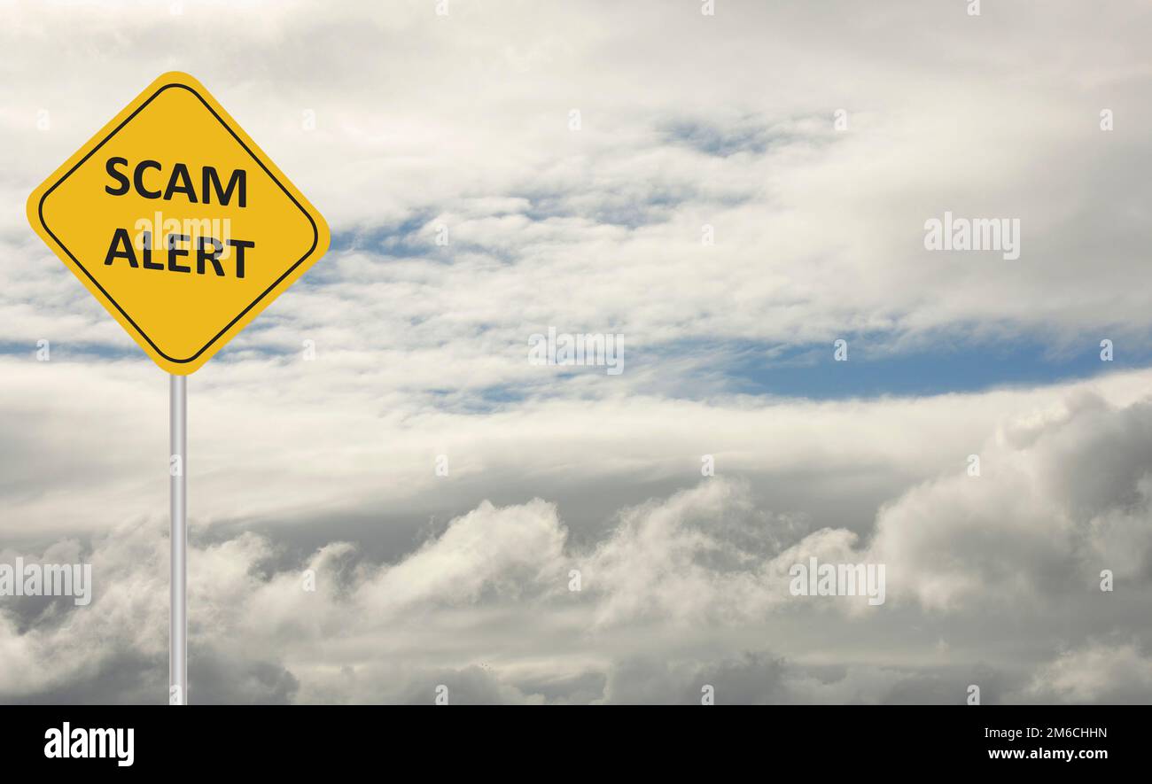 yellow scam alert sign with cloudy sky background Stock Photo - Alamy