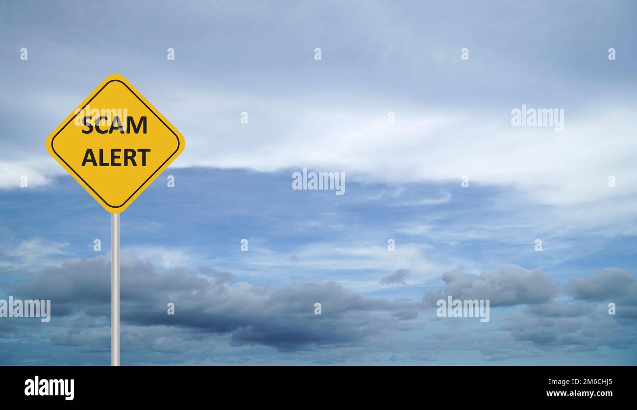 yellow scam alert sign with cloudy sky as background Stock Photo - Alamy