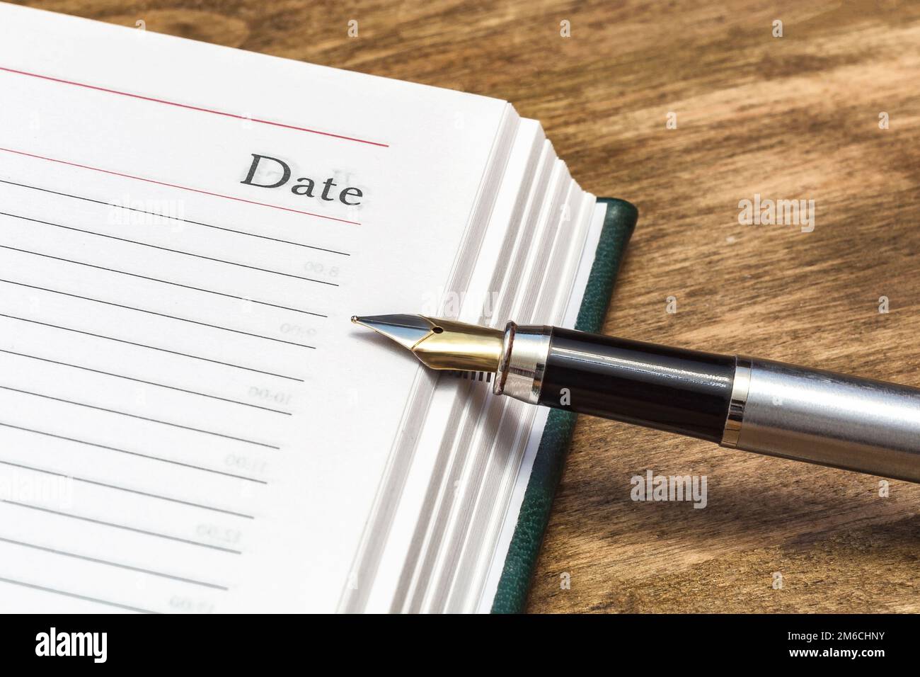 The word date on the page of the open diary and a fountain pen, close ...