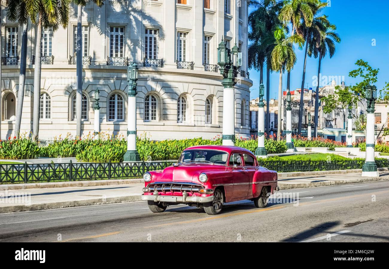 HDR - red brown vintage car drives on the main street in Havana City ...