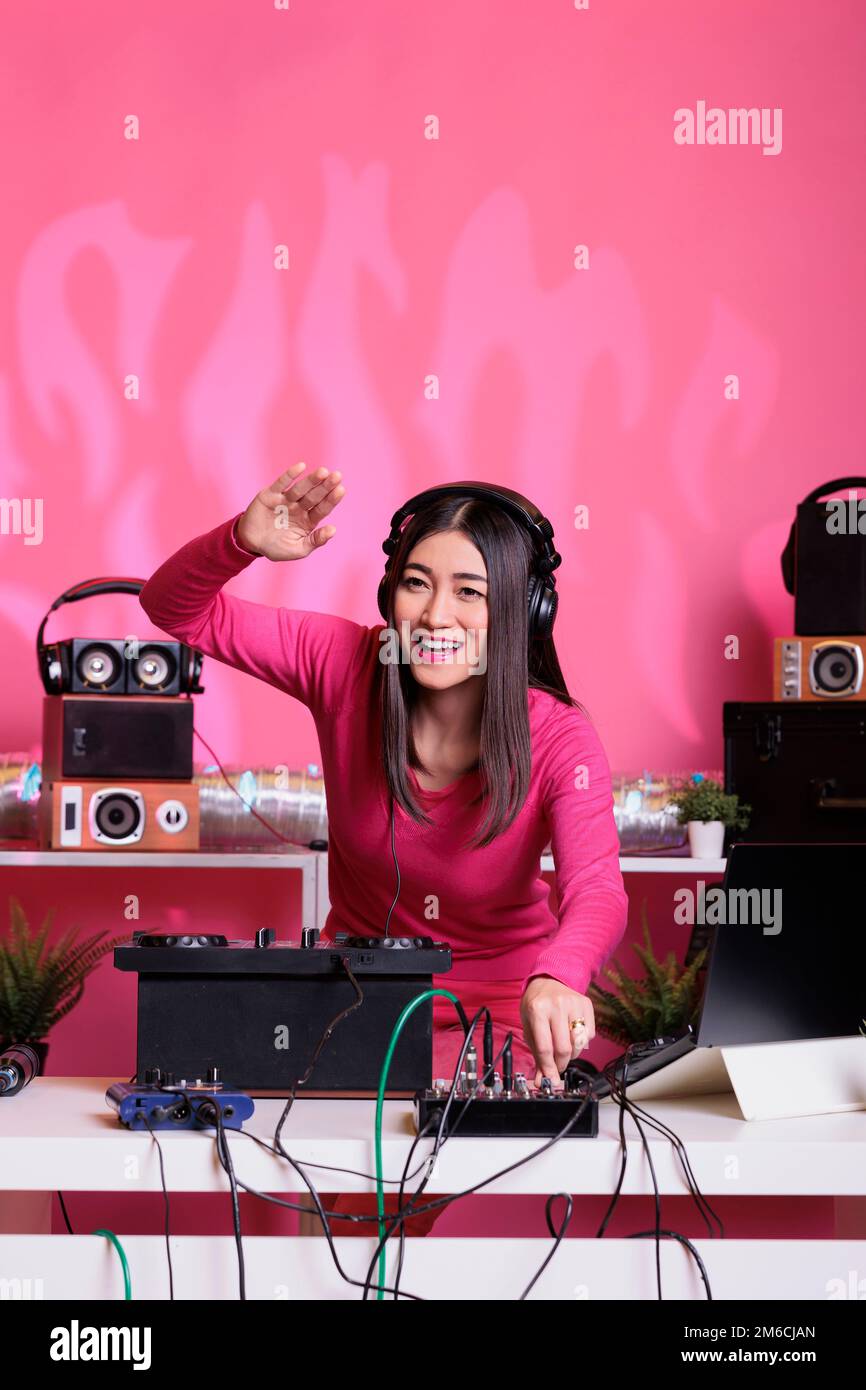 Musician standing at dj table mixing electronic music with techno using ...