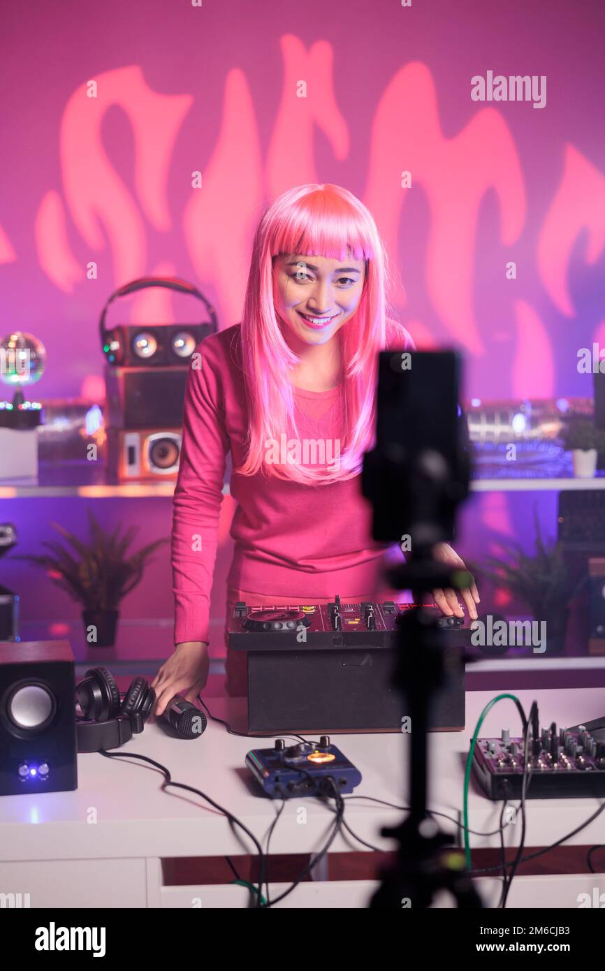 Dj with pink hair recording music session with smartphone camera while ...