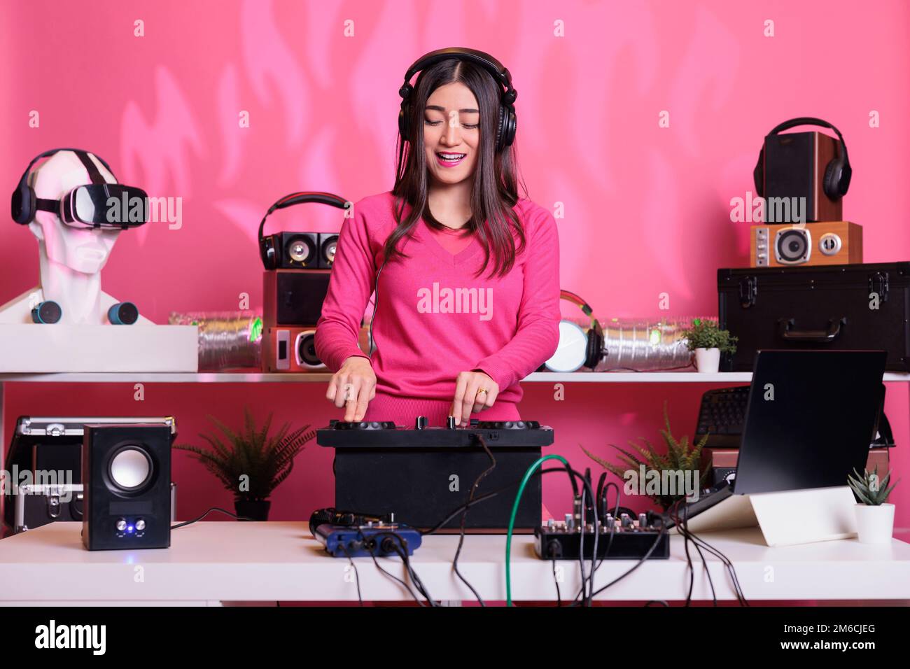 Asian musician performing electronic sound at professional turntables ...