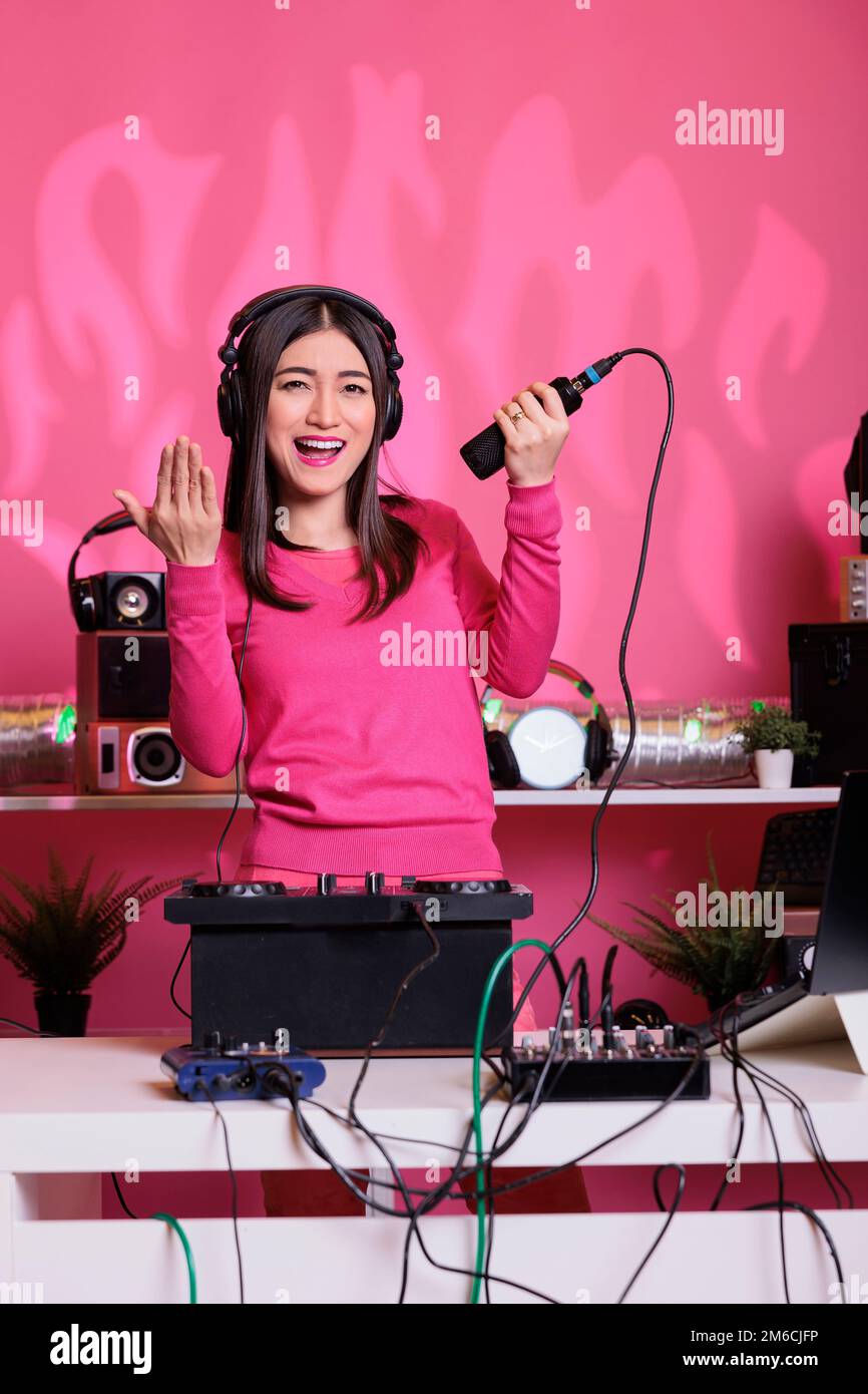 Happy musician having fun while playing eletronic music using ...