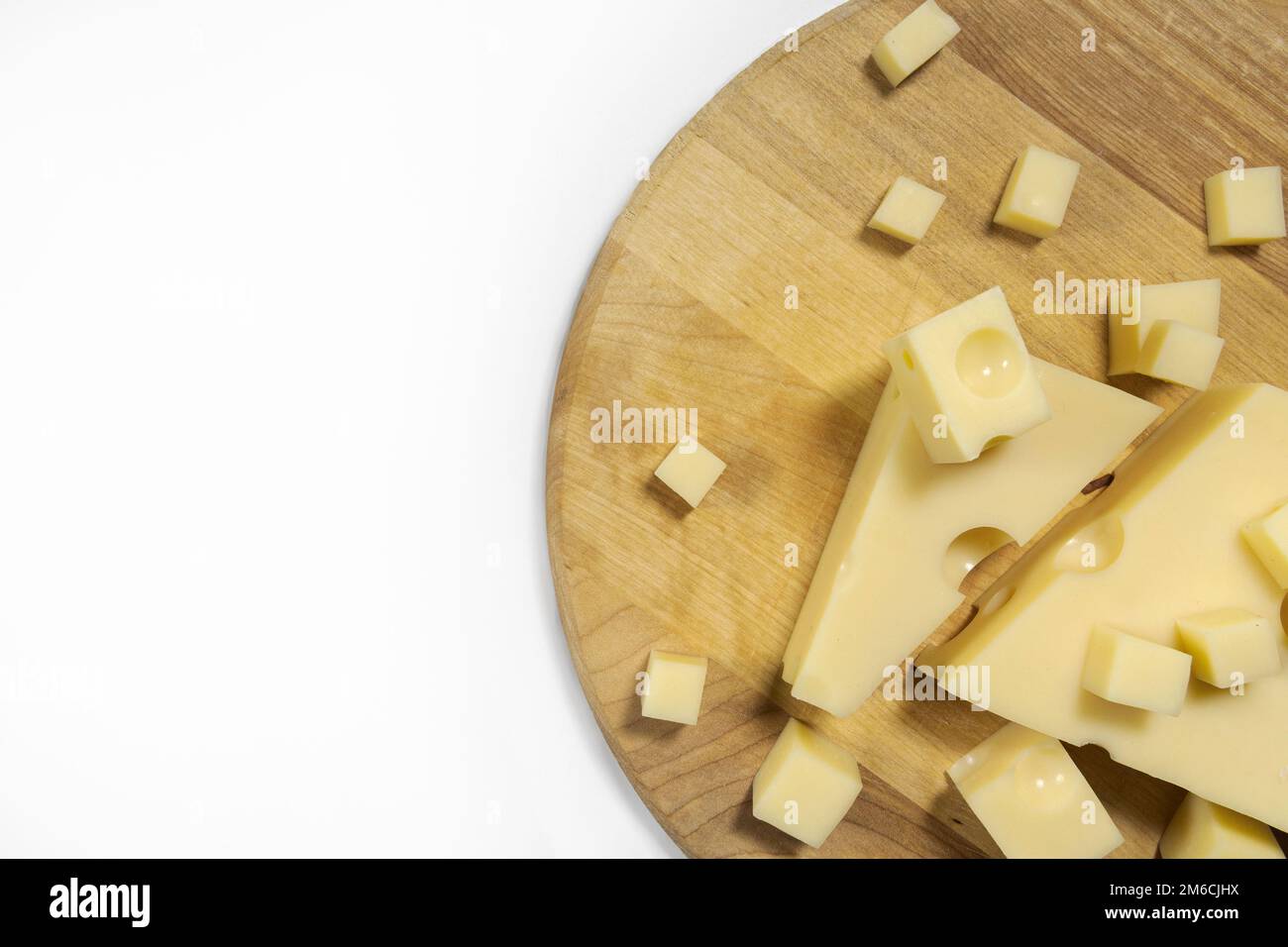 Sliced emmental cheese on a cutting board. Horizontally on a white ...