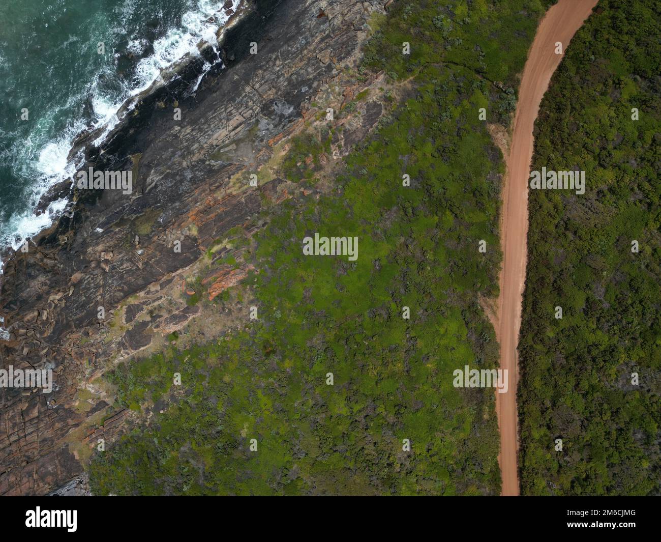 An aerial view of a narrow pathway on cliff covered with nature near ...