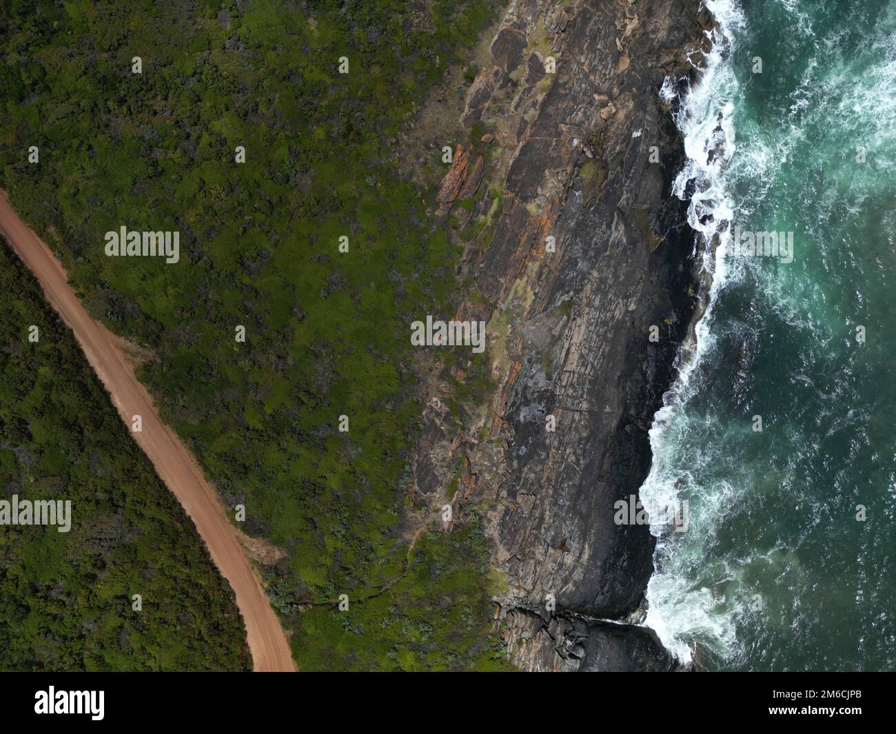 An aerial view of a narrow pathway on cliff covered with nature near ...