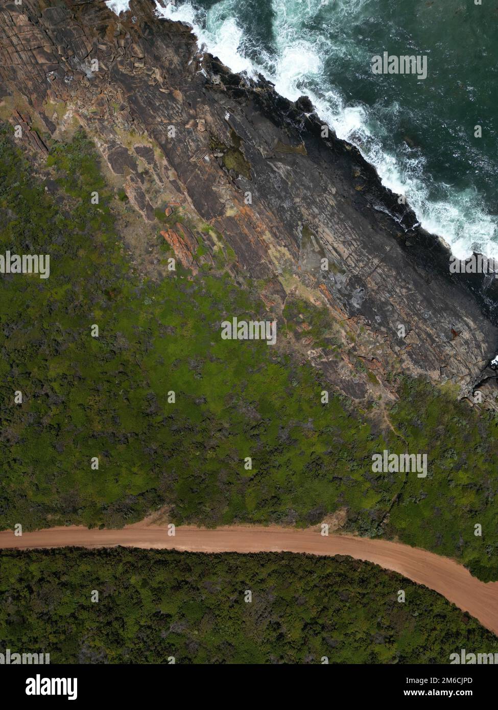 An aerial view of a narrow pathway on cliff covered with nature near ...