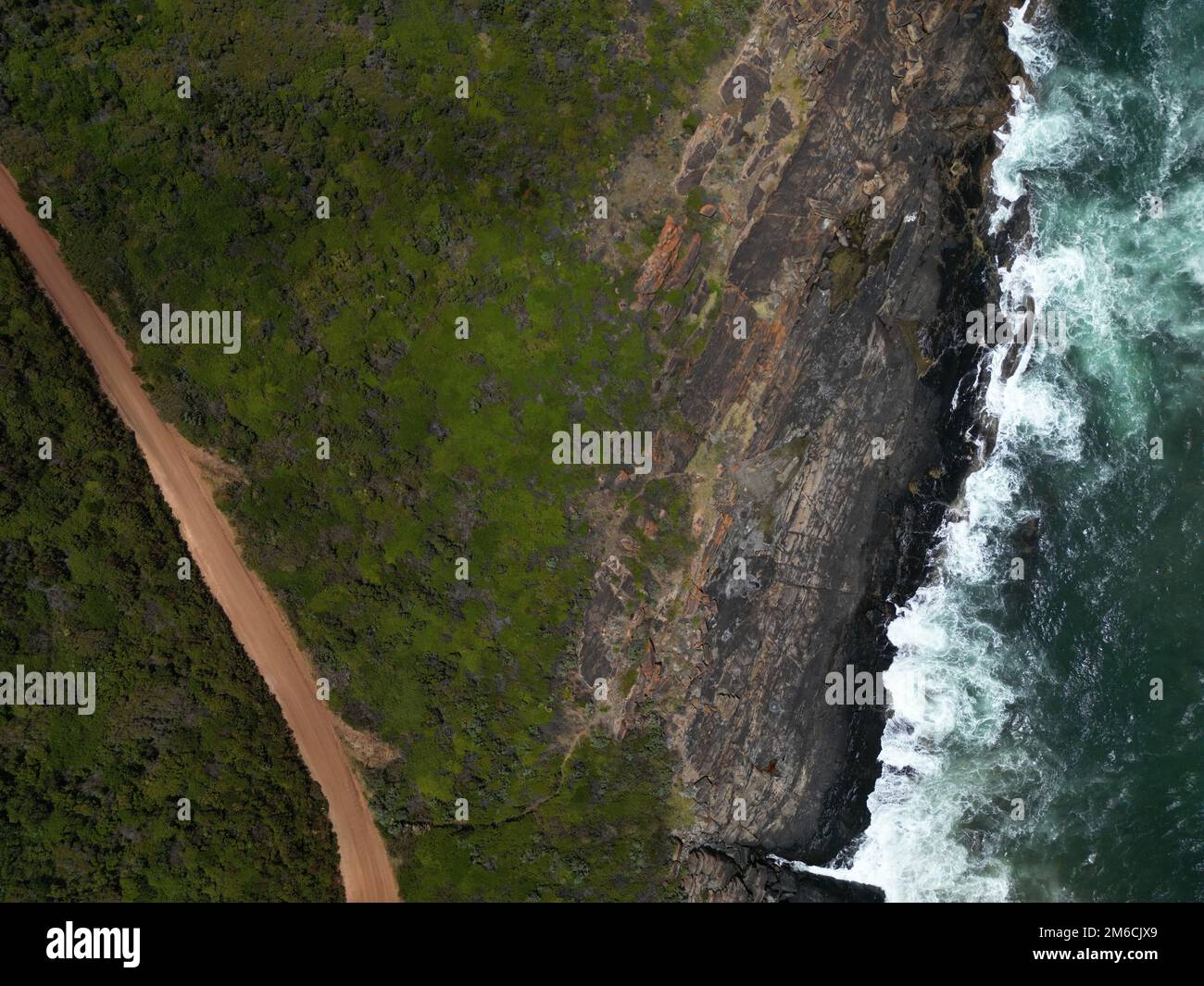 An aerial view of a narrow pathway on cliff covered with nature near ...