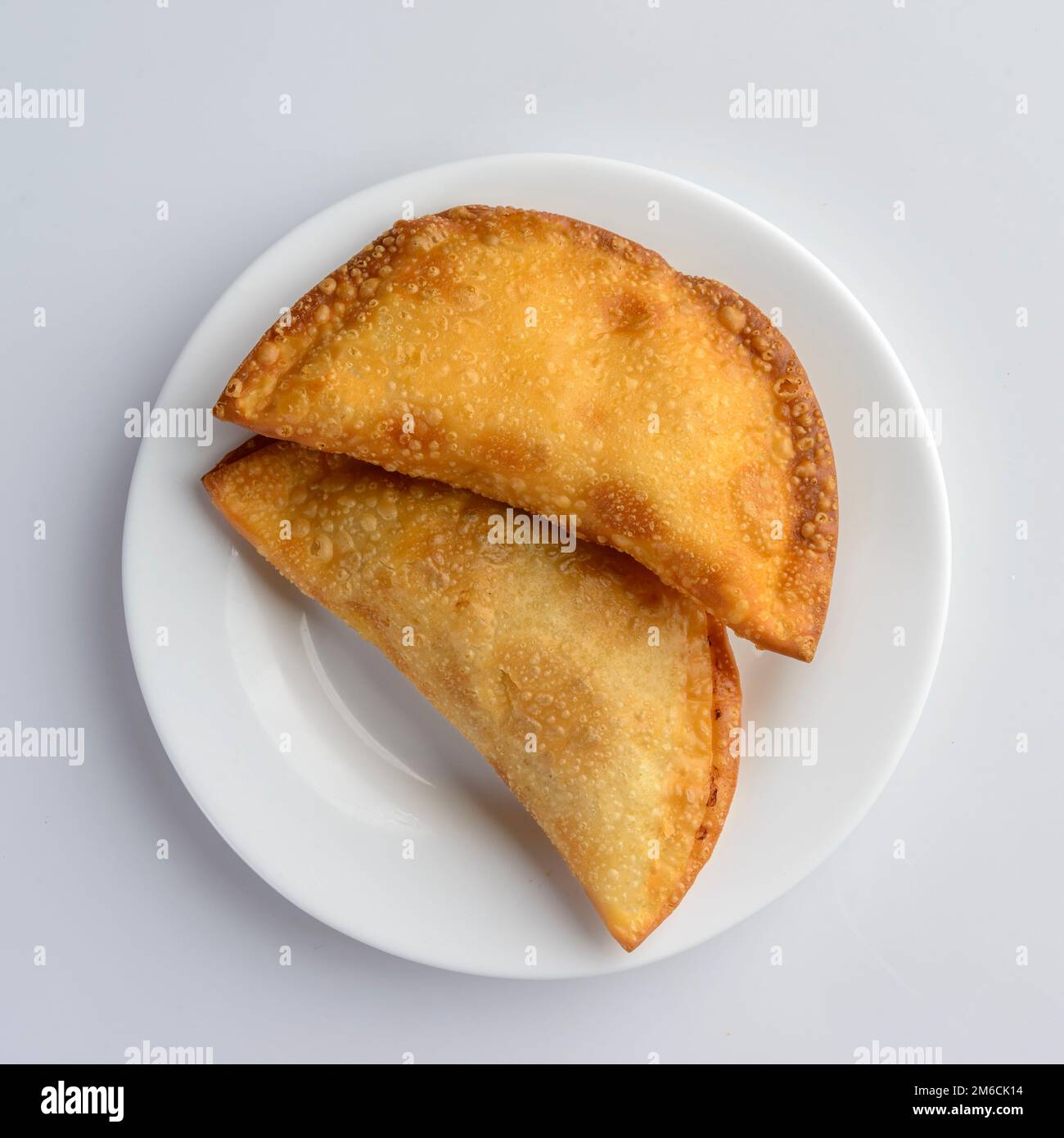 Pastries on white plate. Brazilian traditional pastry known as "pastel ...