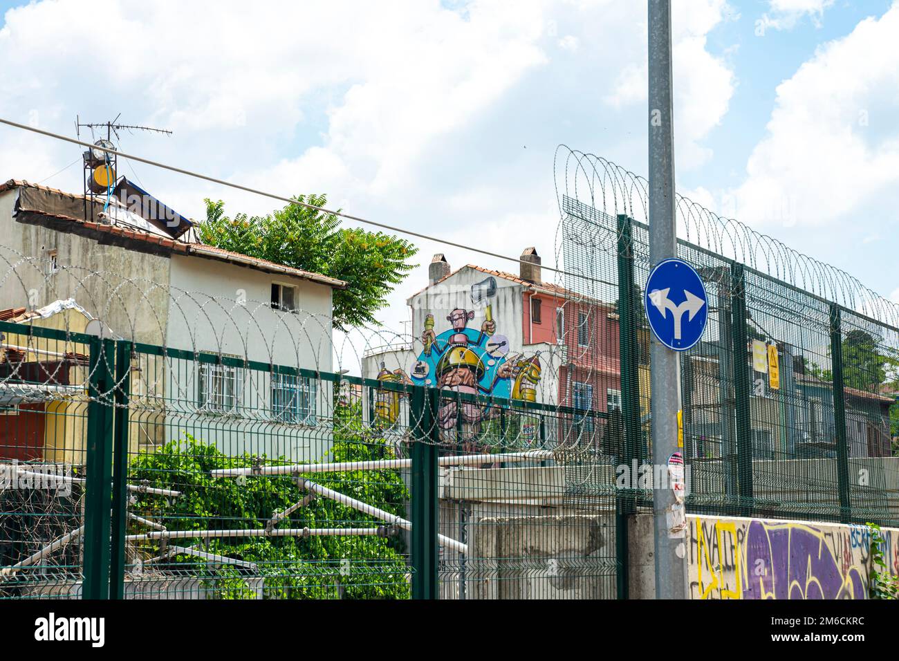 Local railway fence with barbed wire, signs, buildings, urban landscape ...