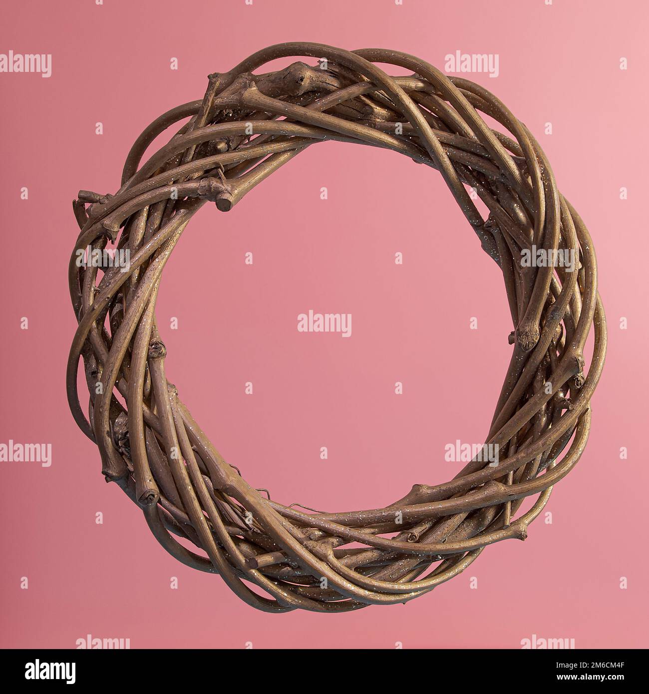 Christmas wreath on a pink background, made of twigs with gilding ...