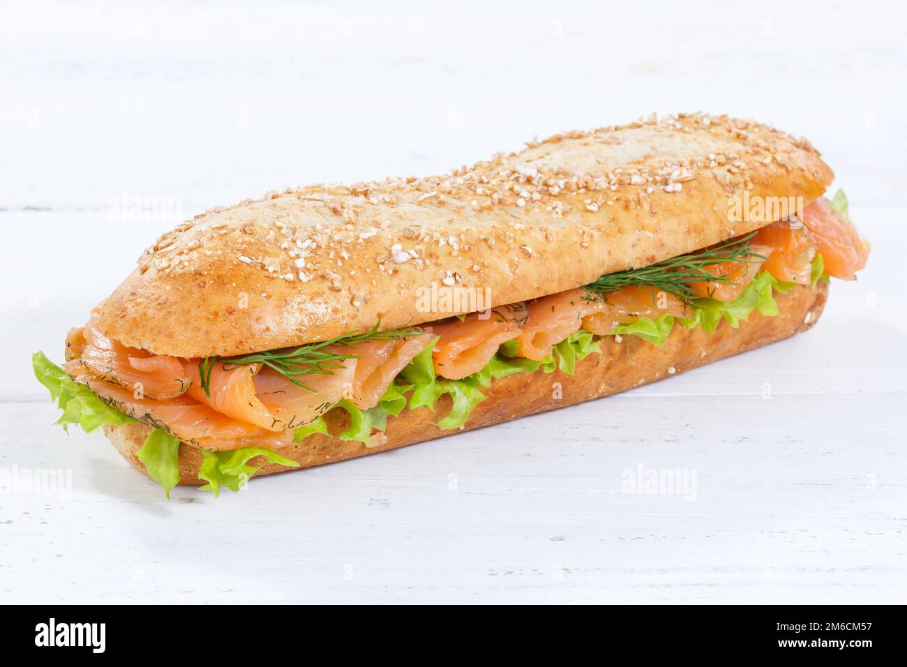 Roll wholemeal baguette topped with salmon fish on wooden board Stock ...