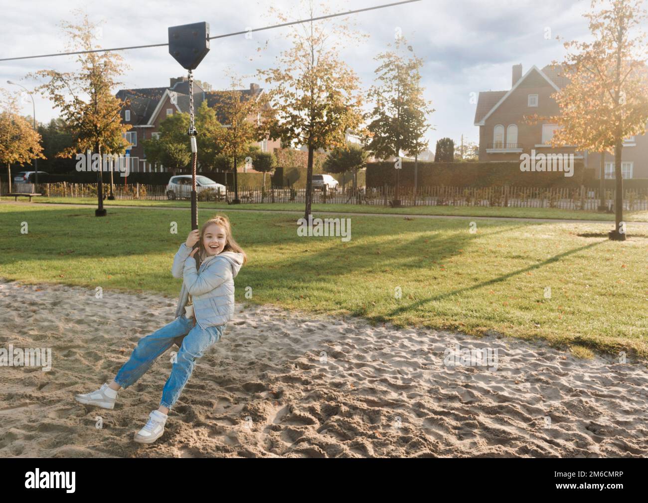 Autumn outdoor fun. Teenage girl riding a hanging bungee on the ...