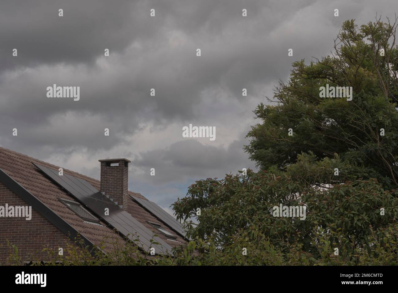 Bad weather before rain. House roof, chimney, solar panels Stock Photo ...