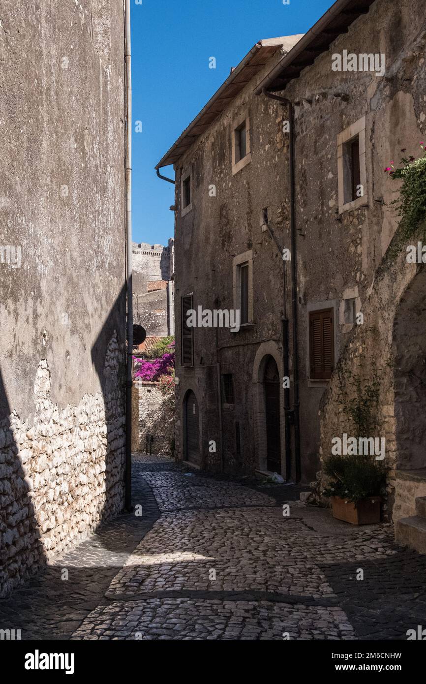 Medieval town alley with the wall of a castle in the background Stock ...