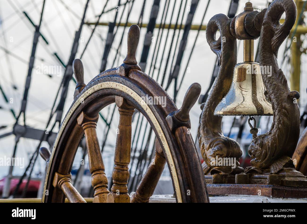Ship's Bell and wheel the old sailboat, close-up Stock Photo - Alamy