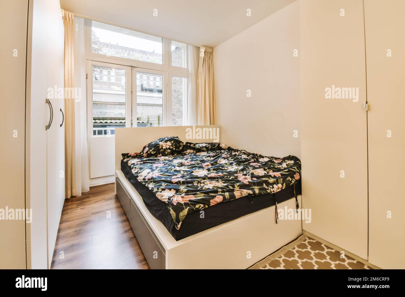 a bedroom with a bed and wardrobes in the corner, there is an open door ...