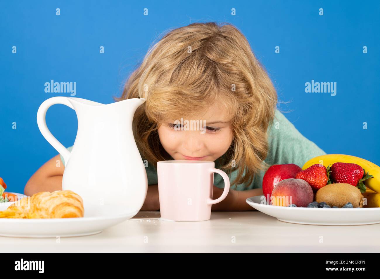 Children eat breakfast. Kid with dairy milk. Kid boy pouring whole cows ...