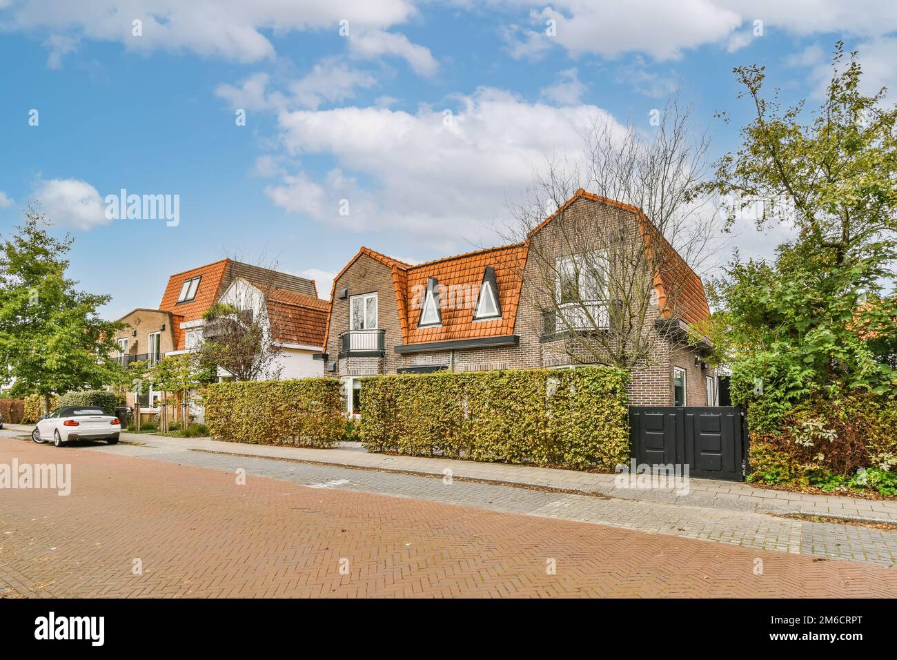some houses on the side of a street with cars parked in front of them ...