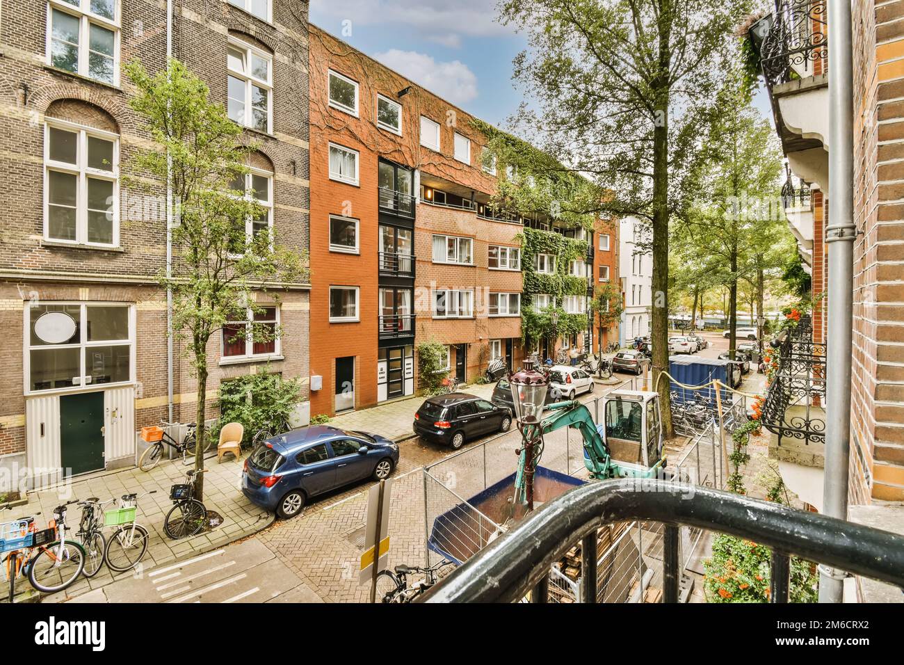 an urban street with parked cars and bicycles in amsterdam, the ...