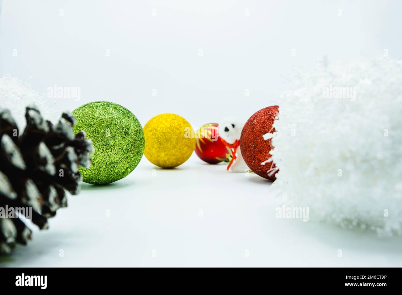 White, green, red, and yellow christmas balls with polar bear and pine ...