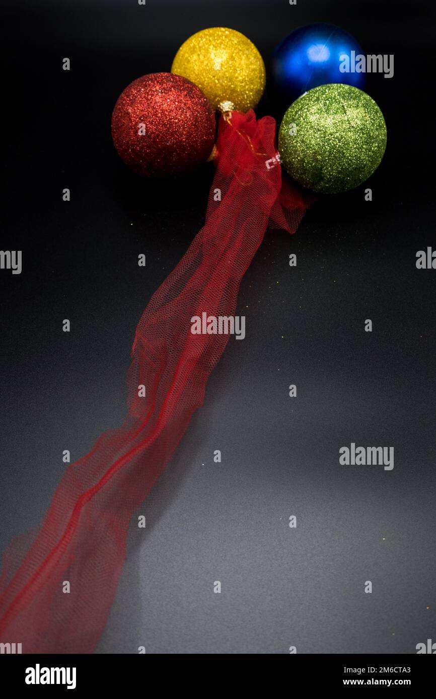 Vertical view of red, yellow, blue and green christmas balls with red ...