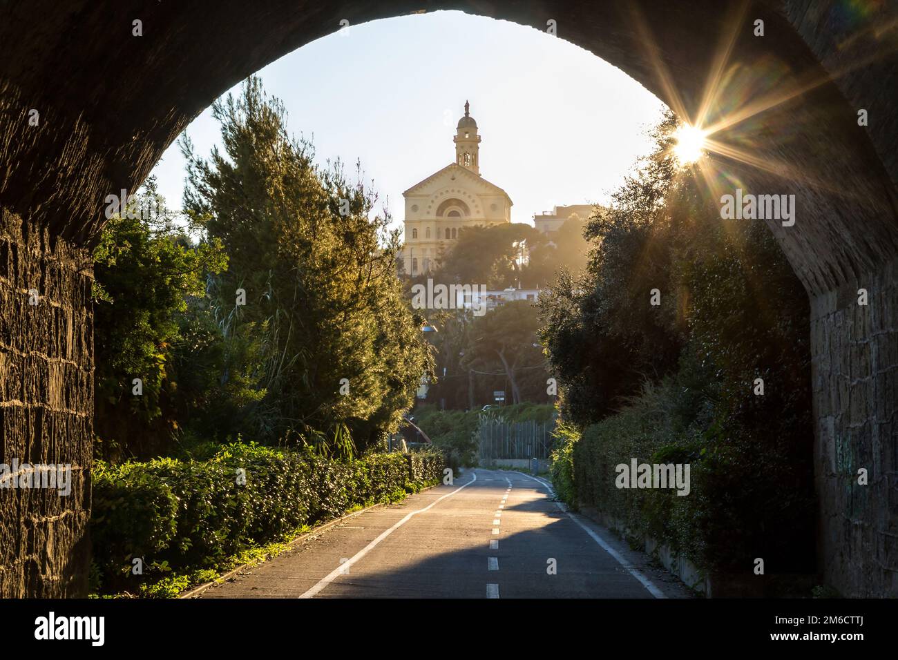 Sunlit arch over a bicycle path in Italy Stock Photo - Alamy