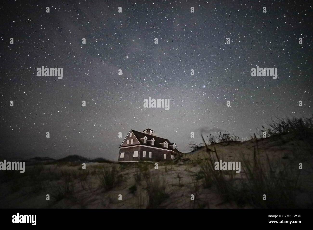 The 1898 Oregon Inlet Life-Saving Station is illuminated by the stars ...