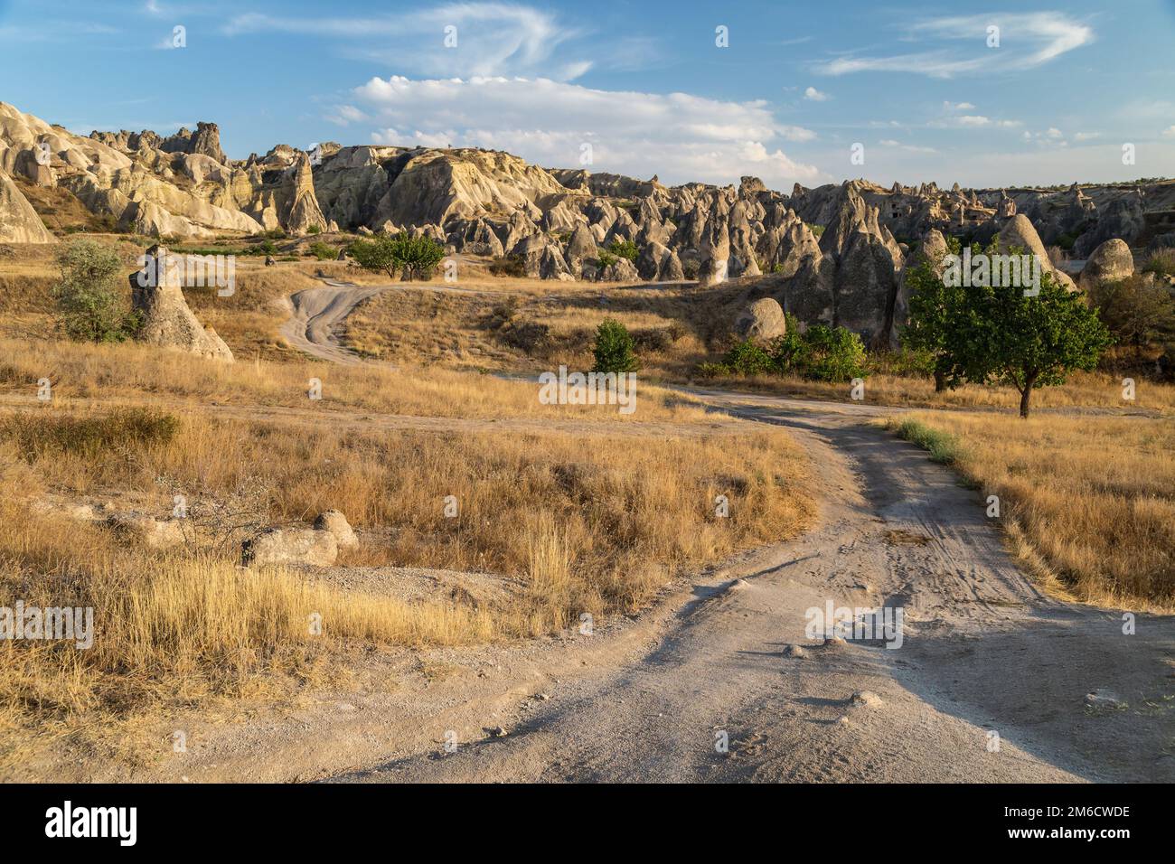 Dirt road through a valley with rock formations in Cappadocia, Turkey ...