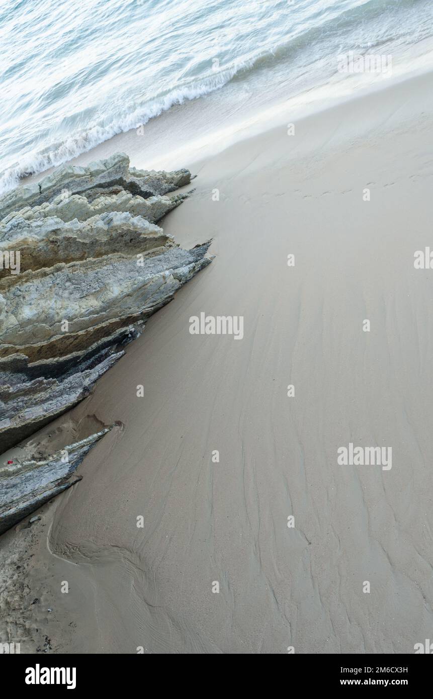 Between de rock, sand and water Stock Photo - Alamy