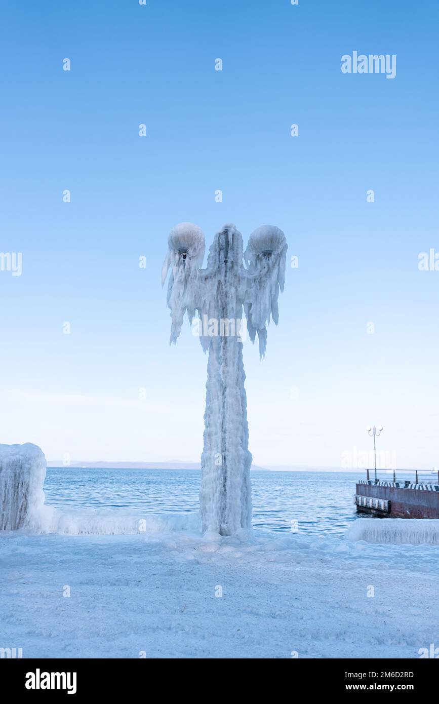 Frozen city after freezing rain. Vladivostok. The street lamp is frozen ...