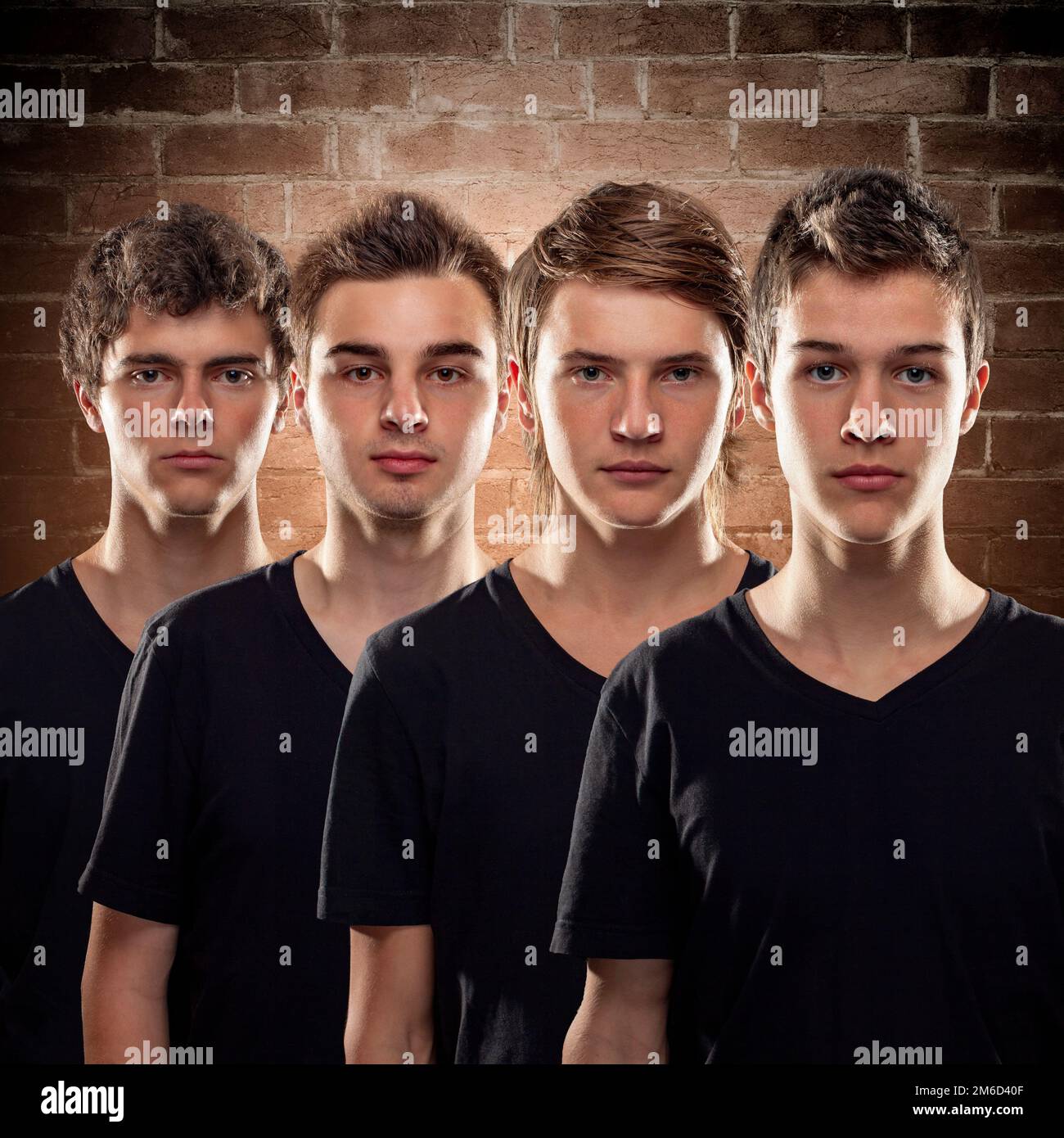 Four young friends stand next to each other in unity Stock Photo - Alamy