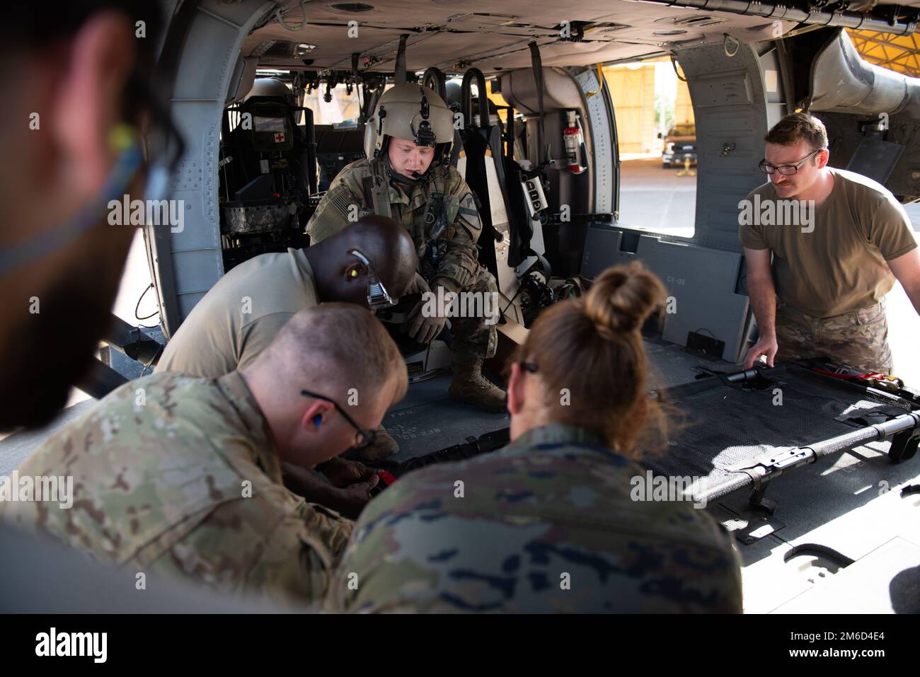 Tactical Combat Casualty Care students fasten a litter to a UH-60 Black ...
