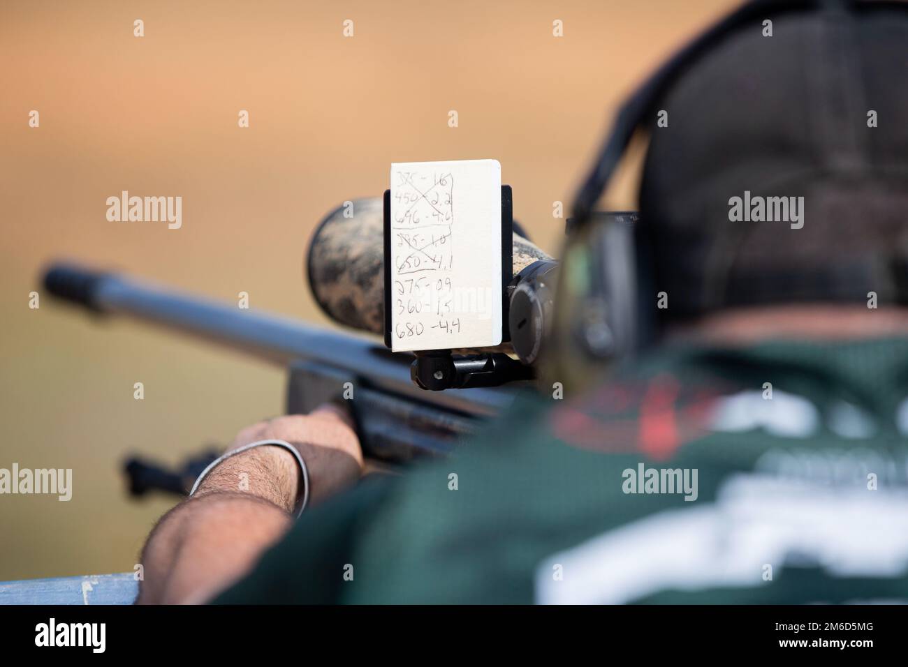 A competitor calculates and dials in his scope in order to properly hit ...