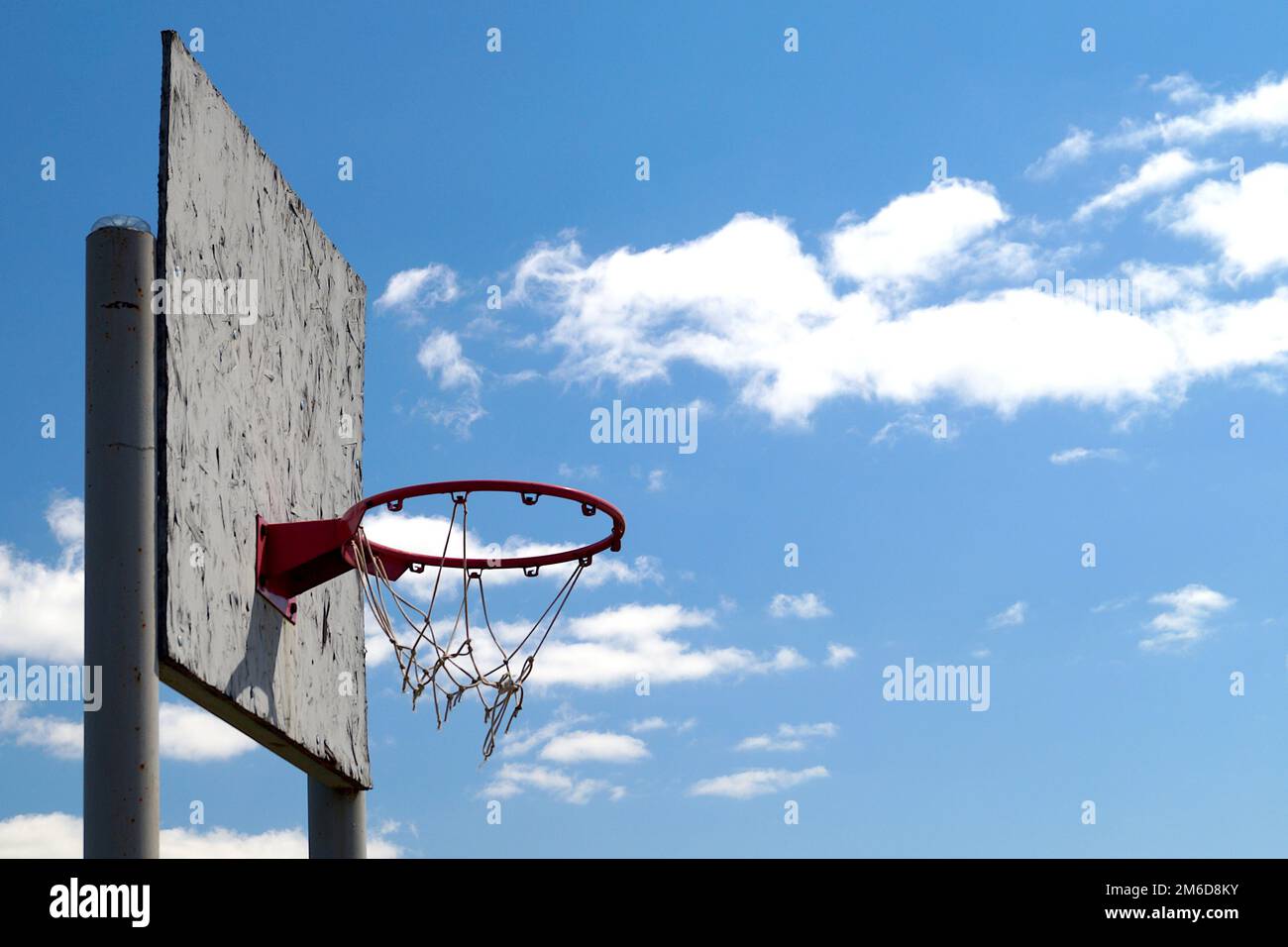 Red basketball hoop for streetball against the blue sky with white ...