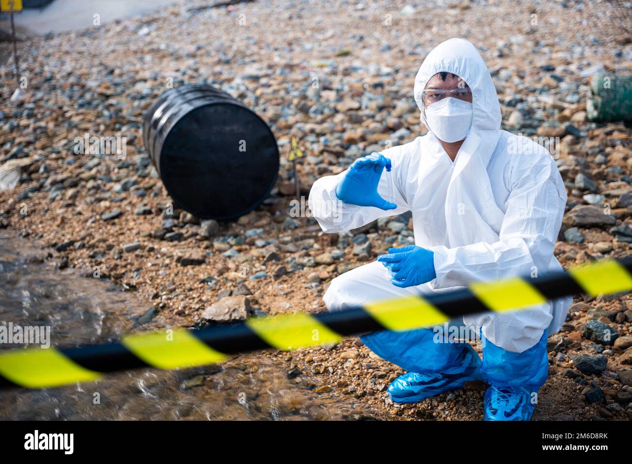 Scientist or Biologist in a protective suit and protect mask collects ...
