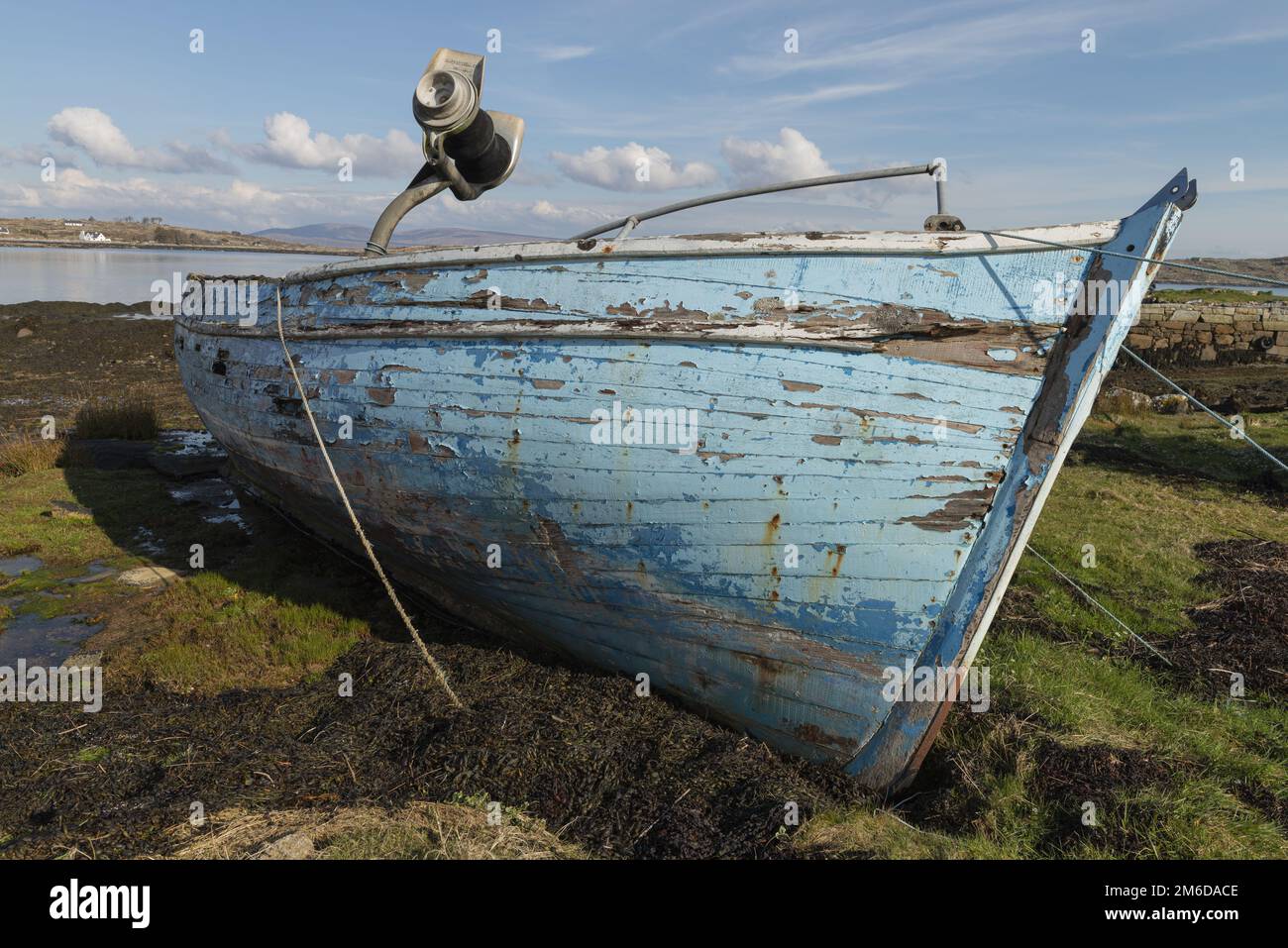 Derelict wooden fishing boat lies decaying on the shoreline on the ...