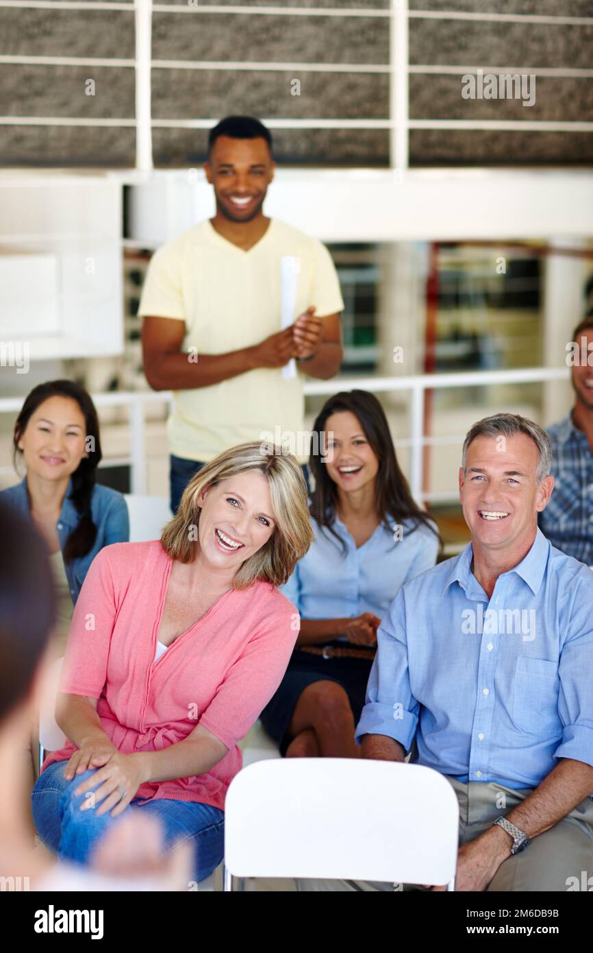 Staff meetings are fun. coworkers watching a presentation in a casual ...