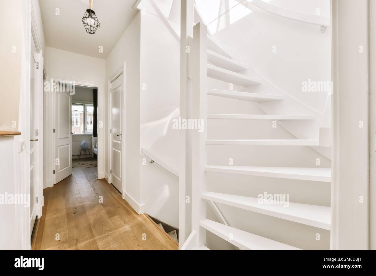 a white staircase with wood flooring and wooden handrails in a home ...