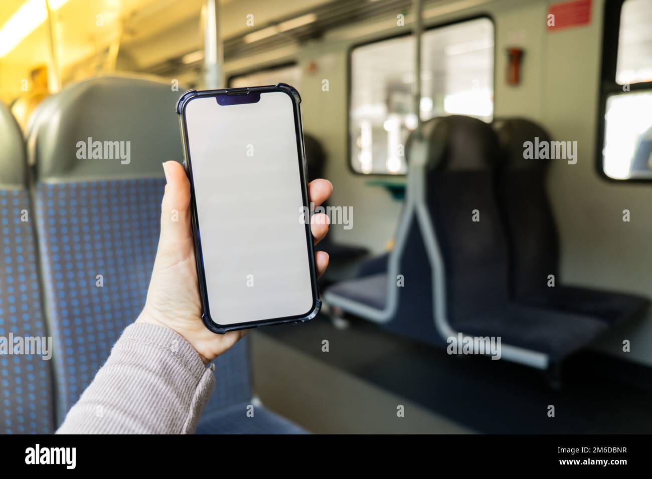 Female hand holding white screen phone in the train. Social Network ...