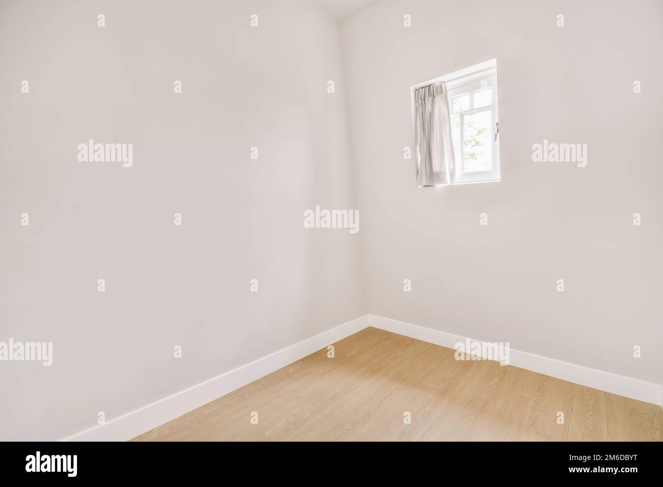 an empty room with white walls and wood flooring, there is a window in ...